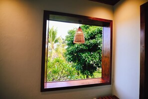 Janela com moldura de madeira e luminária pendente.