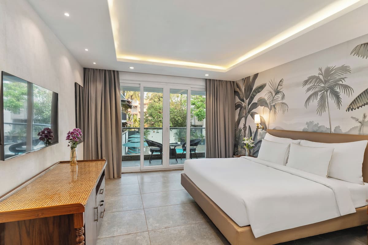 Quarto de hotel moderno com uma cama grande, uma escrivaninha, vista para a piscina exterior e uma varanda.