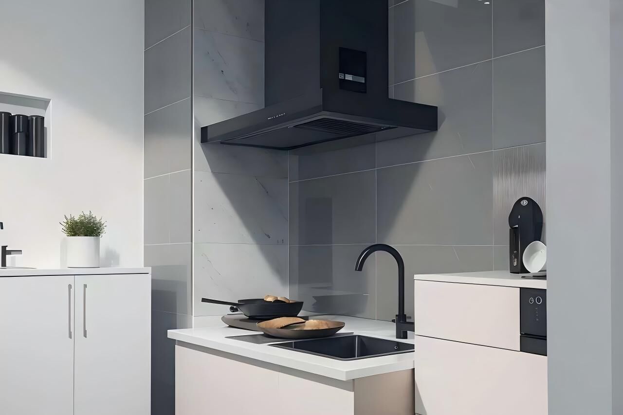 Cozinha moderna com exaustor preto, pia e bancada com tigela e panela.