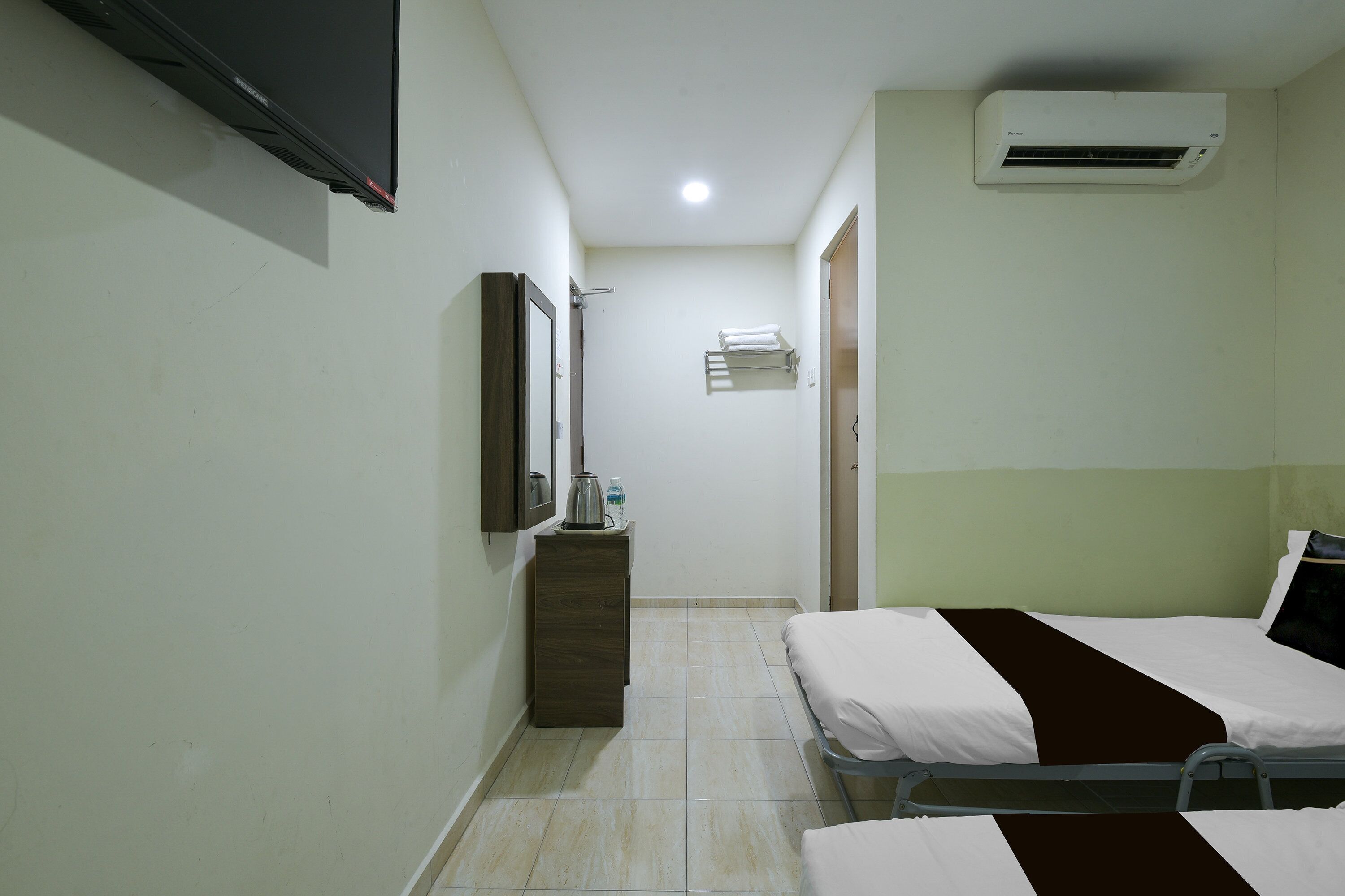 Quarto de hotel com cama, mesa de cabeceira, espelho e ar condicionado.