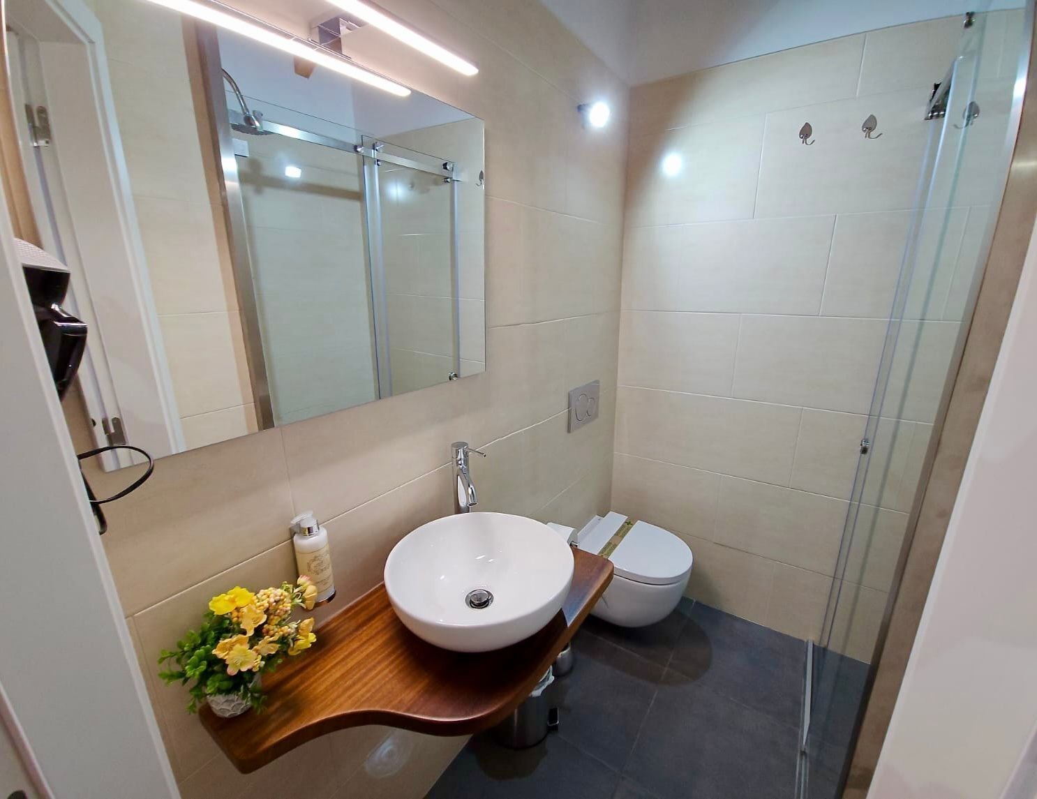 Uma casa de banho moderna com lavatório, espelho e sanita.