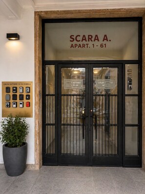 Entrada de um edifício com uma placa indicando 'SCARA A. APART. 1-61'.
