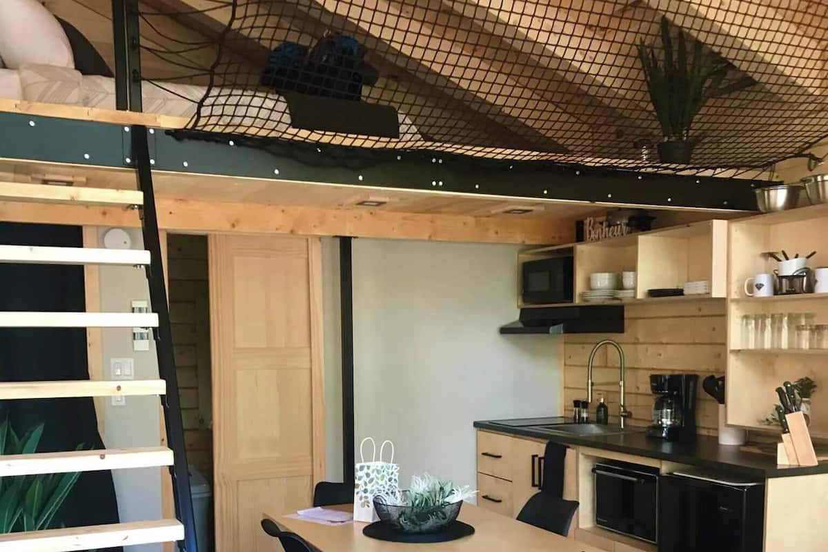 Uma cozinha moderna com área de refeições, piso de madeira e escada.