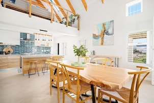 Cozinha espaçosa com teto alto e área de jantar com mobiliário de madeira.