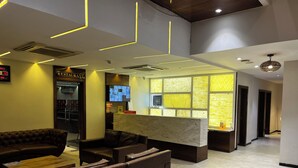 Um lobby moderno com assentos de couro, uma mesa de recepção e um letreiro de restaurante.