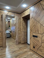 Corredor com painéis de madeira e uma cama ao fundo.