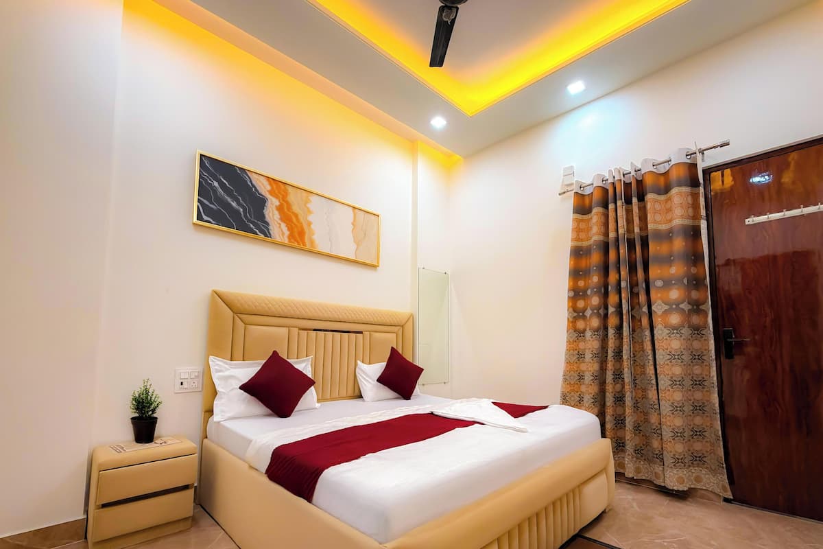Quarto de hotel com cama, mesa de cabeceira e espelho.