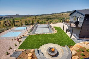 Um imóvel residencial com quadra de basquete, piscina, lareira e vista da paisagem ao redor.