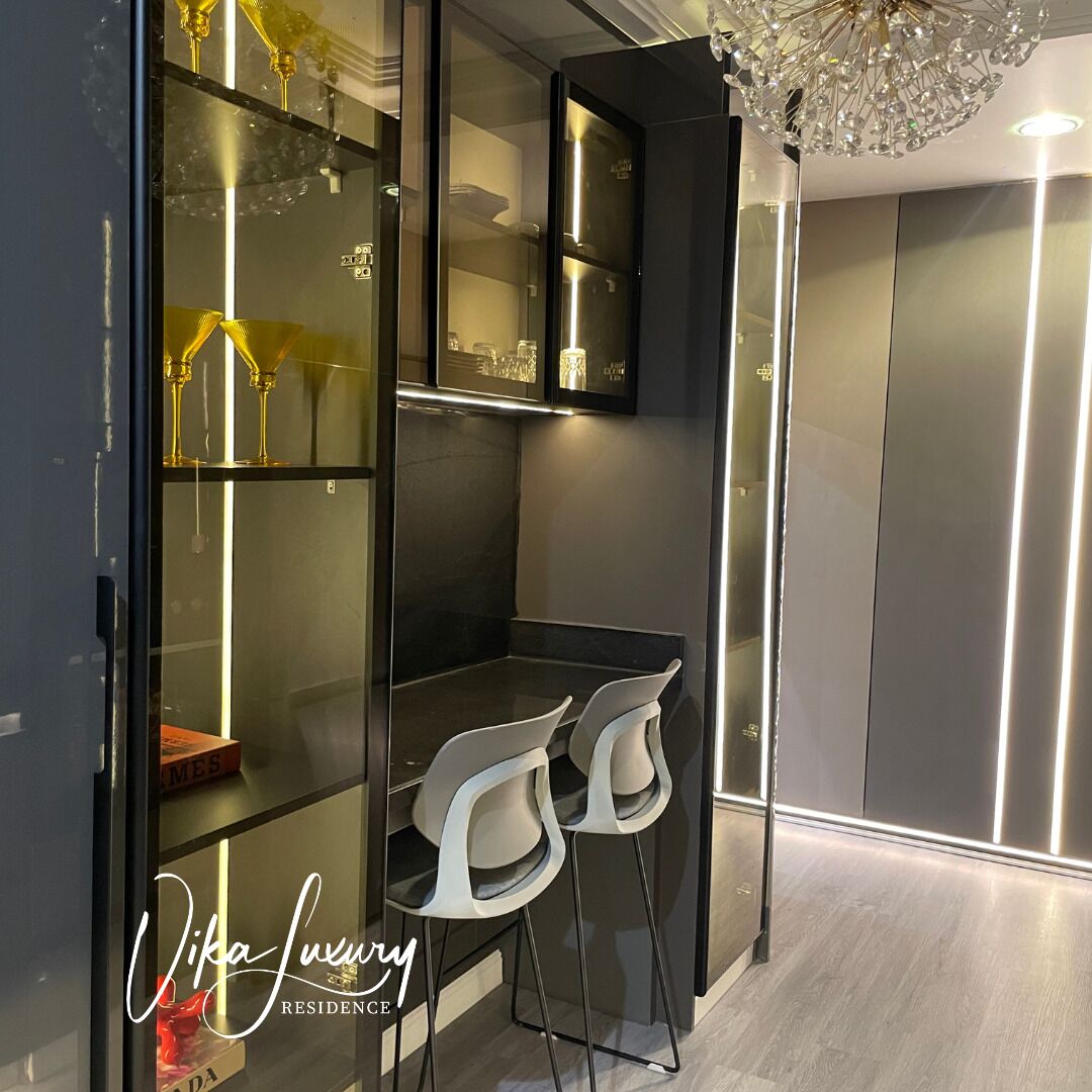 Um interior moderno com um armário de vidro, um candelabro e uma área de jantar com cadeiras.