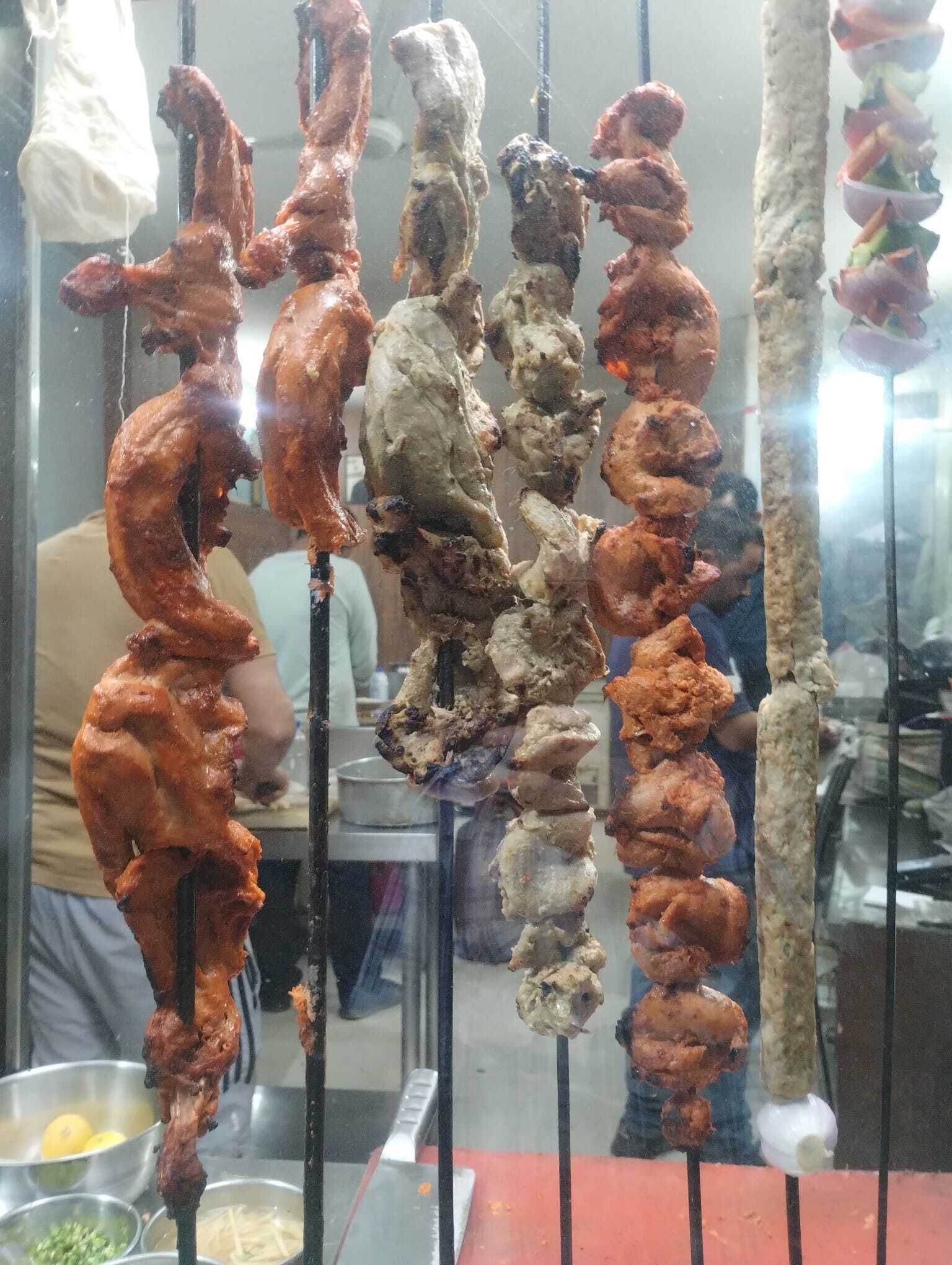 Restaurante com carnes espetadas expostas.