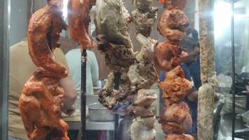 Restaurante com carnes espetadas expostas.