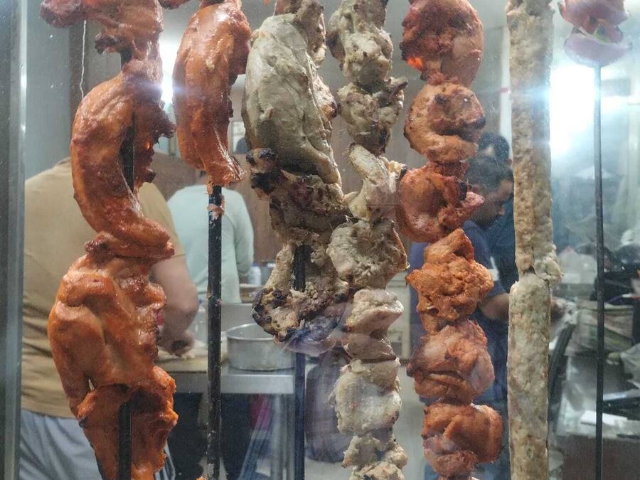 Restaurante com carnes espetadas expostas.