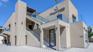 Um hotel moderno com área de recepção, escada e uma palmeira.