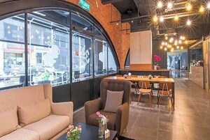 Um interior moderno com uma parede curva, área de estar e vista para a rua.