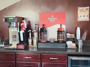 Um espaço de café com máquina de café, café descafeinado e um letreiro da Seattle's Best Coffee.