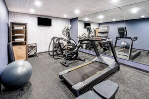 Academia com esteiras, elípticos e bolas de exercício.