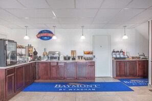 Balcão de café da manhã com placa Baymont, máquina de café e aparelho de waffle.