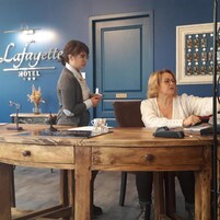 Balcão de recepção de hotel com uma placa indicando 'Lafayette Hotel' e uma porta 'Privada'.