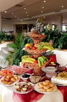 Buffet com frutas, doces e uma mesa escalonada de frutas.