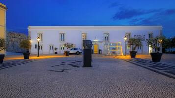 Um edifício branco com uma placa que diz 'Pousada Cascais Hotel District'.
