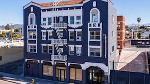 Um edifício de vários andares com escada de incêndio, janelas amplas e entrada de garagem.