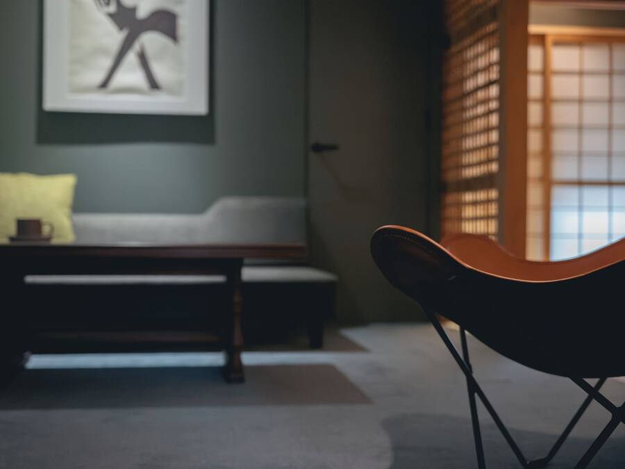 Um quarto com sofá, mesa de centro e uma cadeira.