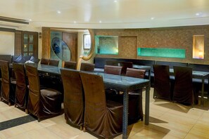 Uma sala de conferências com mesa de vidro, cadeiras marrons e design moderno.