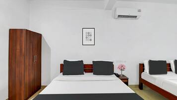 Quarto com cama, duas mesas de cabeceira, guarda-roupa, ar condicionado e um quadro na parede.