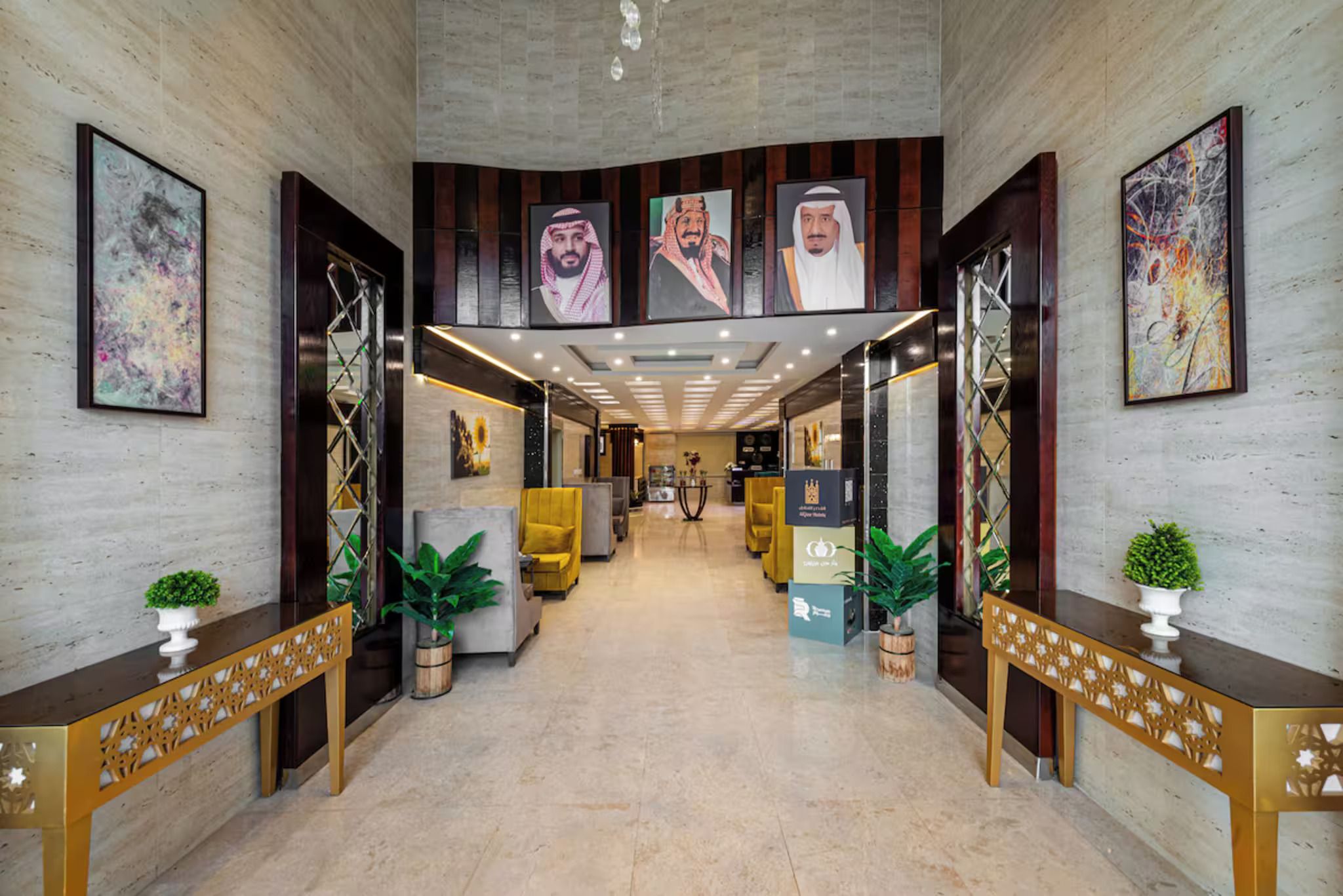 Um hall de hotel com piso de mármore, mobiliário moderno e obras de arte nas paredes.