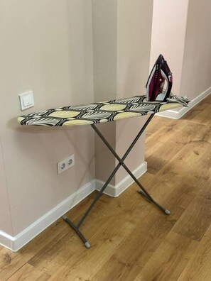 Um ferro de passar roupa fixado na parede, com um ferro e um pano.