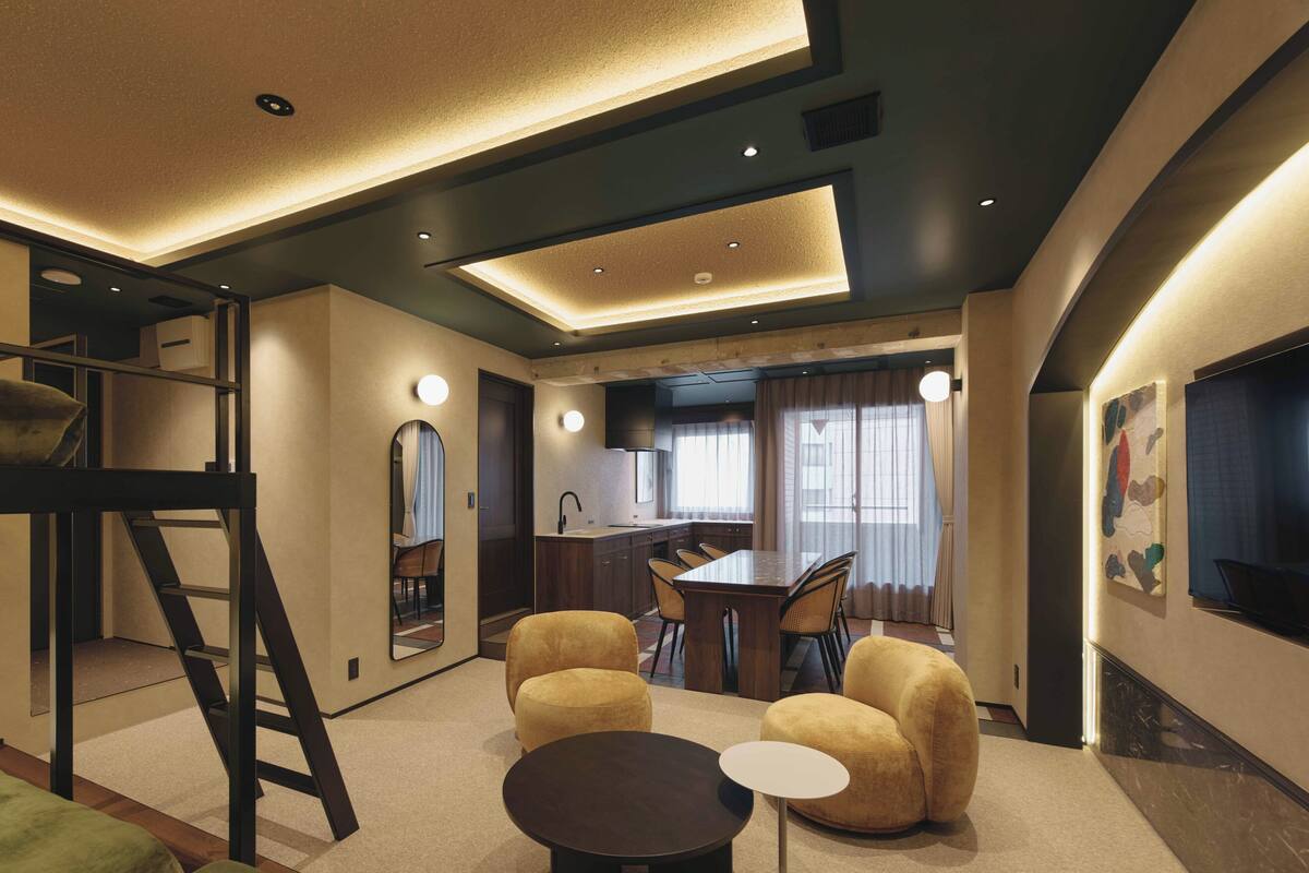 Interior moderno com área de refeições, cozinha e um mezanino acessível por escada.