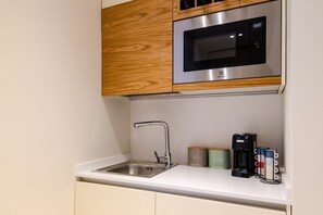 Um micro-ondas, uma máquina de lavar louça, uma cafeteira/bule 