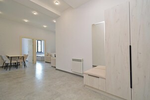 Quarto moderno e minimalista com área de jantar, um espelho grande e um banco embutido.