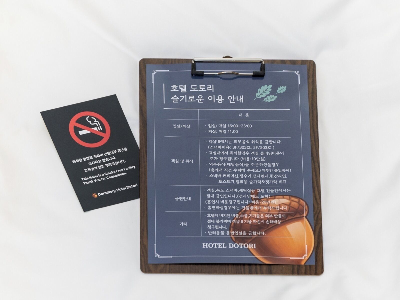 Quadro de informações do hotel com aviso de proibido fumar, horário de funcionamento e comodidades.