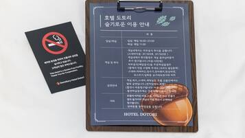 Quadro de informações do hotel com aviso de proibido fumar, horário de funcionamento e comodidades.