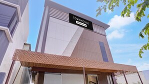 Um edifício moderno com uma placa que diz 'TOWNHOUSE' e 'oyo-Serviced'.
