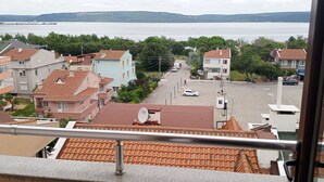 Zona residencial com edifícios, uma rua e um corpo de água ao fundo.