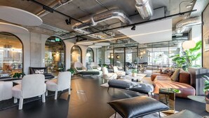 Um interior moderno com áreas de estar, um bar de café e grandes janelas.