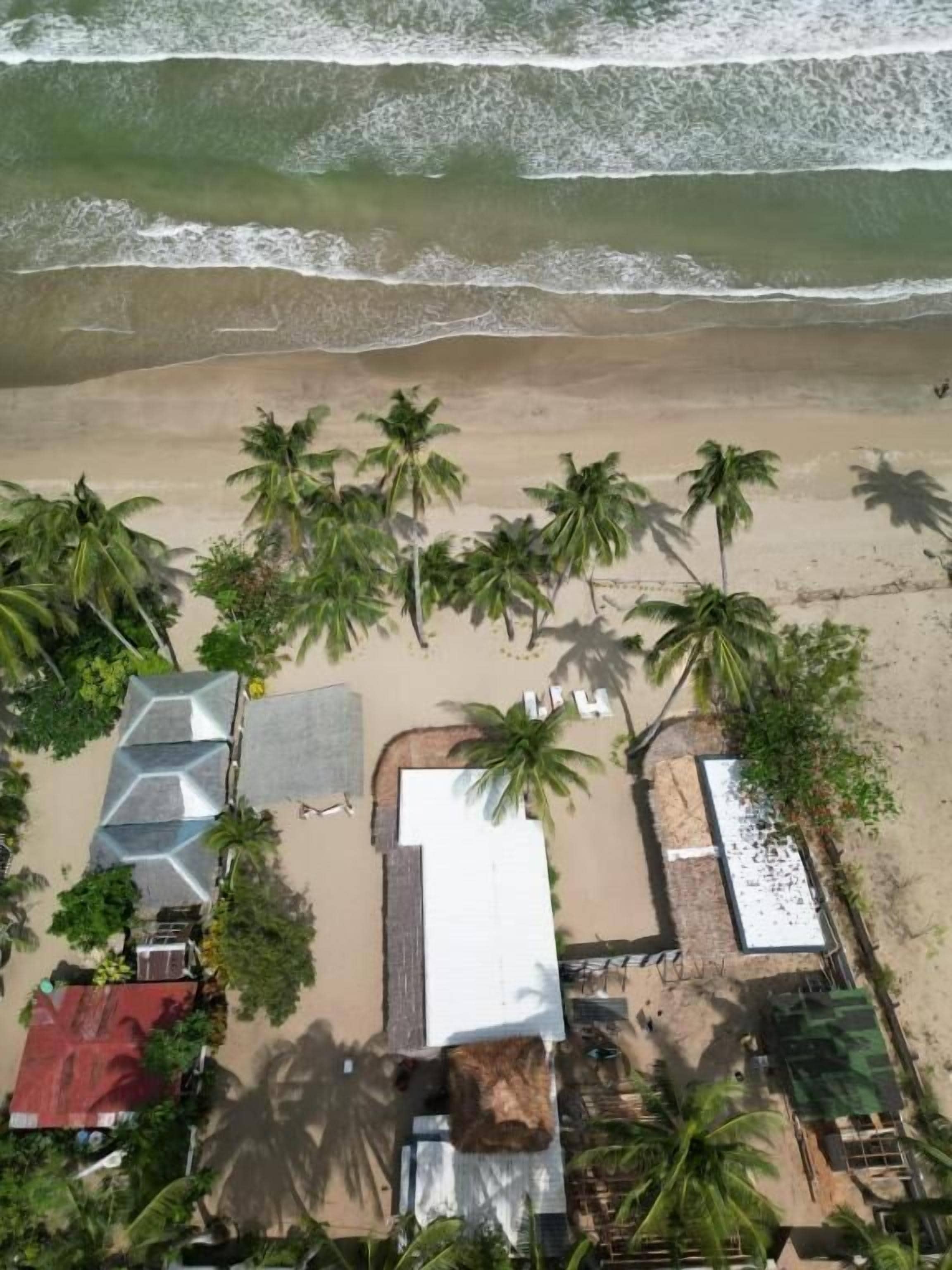 Praia particular, areia branca, espreguiçadeiras, guarda-sóis 