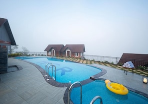 Piscina com cadeira de salva-vidas e um flutuador amarelo.