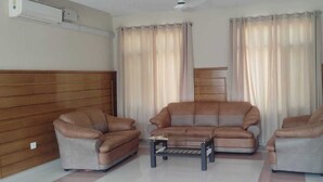 Uma sala de estar com sofá, mesa de centro e cabeceira de madeira.