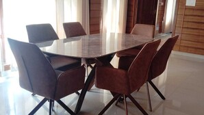 Uma sala de jantar com uma mesa retangular e seis cadeiras.
