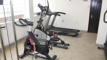 Uma academia com bicicletas ergométricas e esteiras.