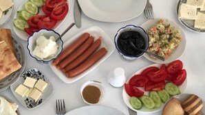 Uma mesa com diversos alimentos, incluindo cachorros-quentes, queijo e vegetais.