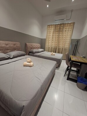 Quarto de hotel com duas camas, uma escrivaninha, uma cadeira, ar condicionado e cortina.