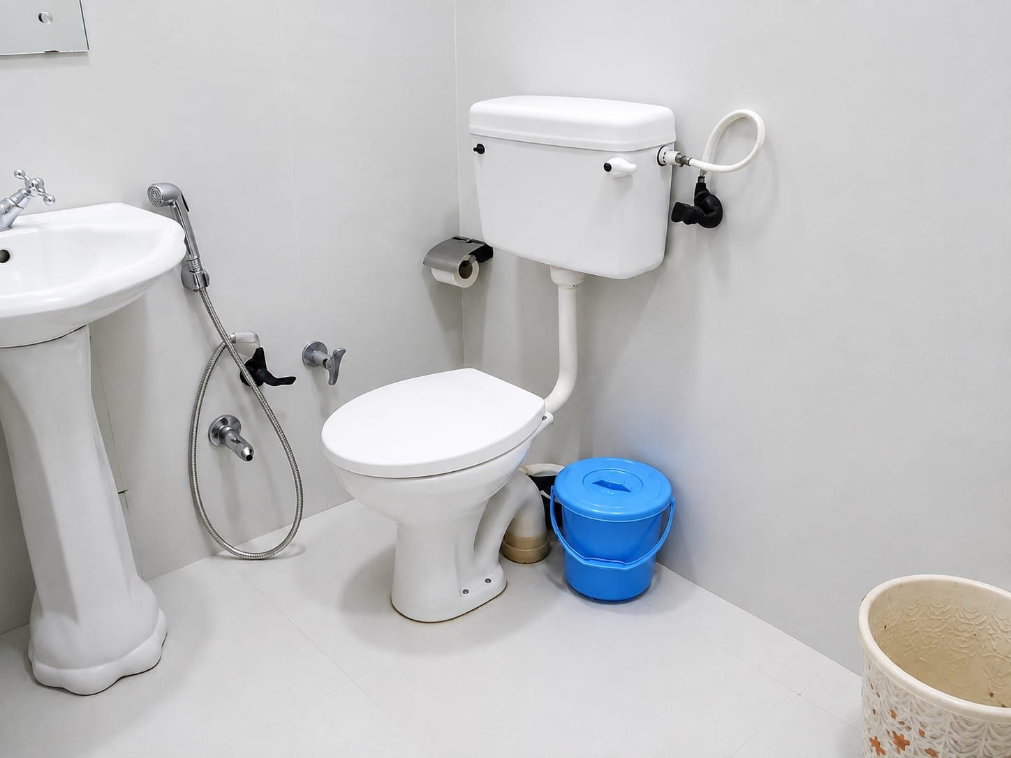 Um banheiro com vaso sanitário branco, pia e chuveiro.