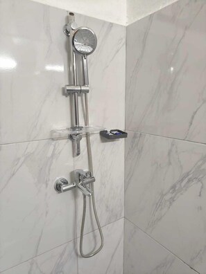 Chuveiro, toalhas de banho, sabonete, shampoo