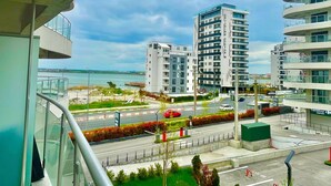 Um edifício moderno com vários andares, área de estacionamento e vista para o mar.