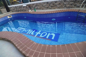 Piscina com borda azulejada e escada.