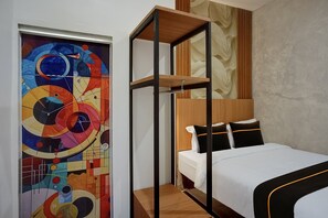 Quarto moderno com beliche, uma pintura abstrata colorida na parede e cabeceira de madeira.